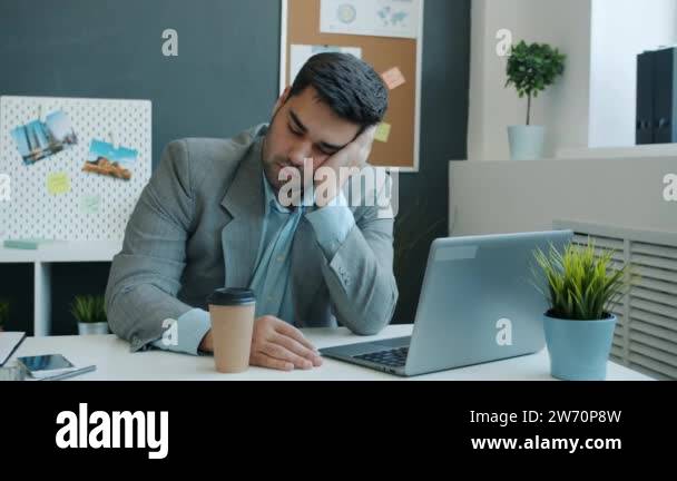 Sleepy employee napping at desk then waking up and working with ...