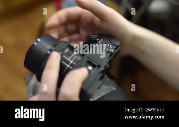 She sets up the camera before shooting. Man turns the wheels of the ...