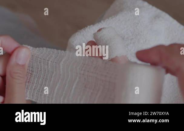 Mother bandages her childs big toe. Close-up photo of kids foot with ...
