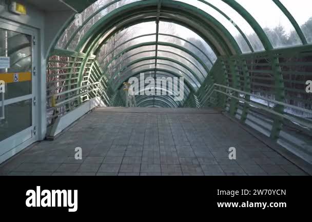 Walking Inside newly built modern pedestrian bridge over the highway ...