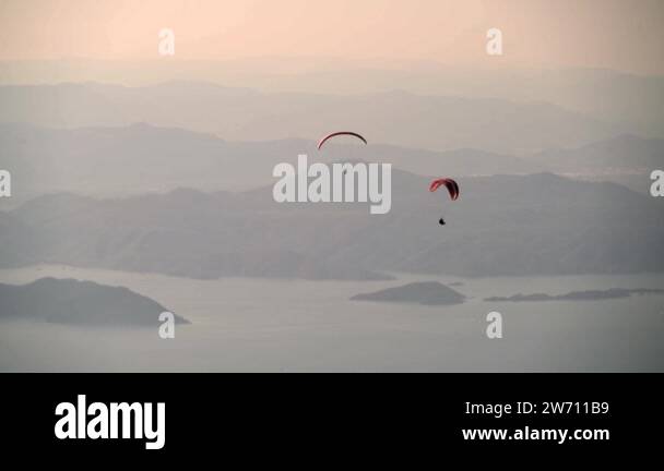 Paragliders flying with paragliding in sky over the forest, mountain ...