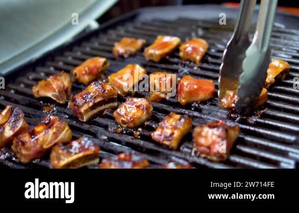 Turning basted short ribs on BBQ. Roasting delicious short cut ribs on ...