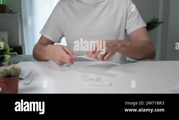 Man opening package with nasal swab to take rapid self test for ...