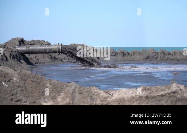 Mud comes out in slow motion from a pipe at the beach Stock Video ...