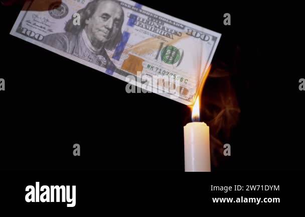 Burning 100 Dollar Bill over a Smoky Candle Flame on a Black Background ...