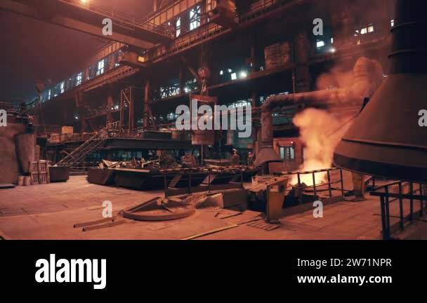 Foundry interior. Blast furnace with fire and smoke and moving bucket ...
