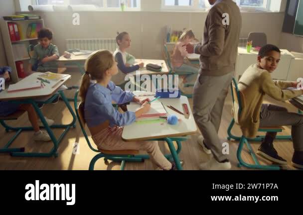 Teacher explaining lesson to students in classroom. Smart kids having ...