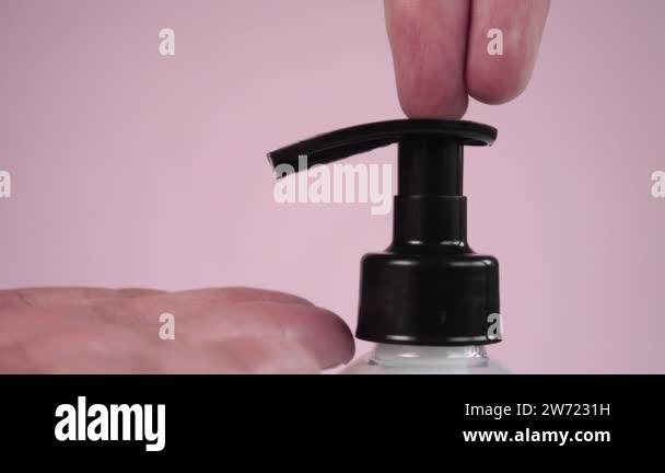 Using liquid soap from a plastic container to wash and disinfect hands ...