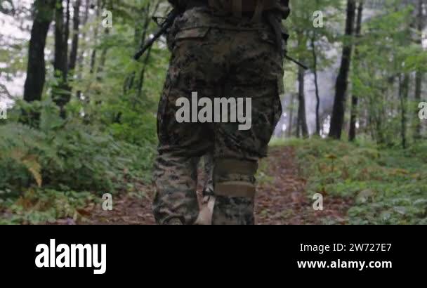 Fully equipped soldiers wearing camouflage uniform and moving through ...