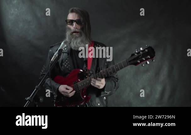 Bearded hairy rocker in retro black sunglasses with shaved temples and ...