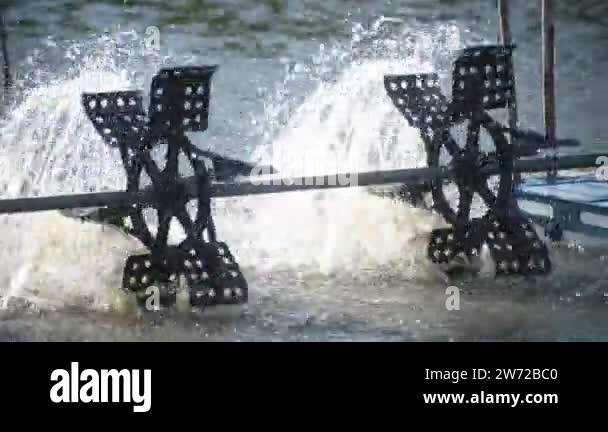 A water turbine used to rotate the water in the aquaculture pond with a ...