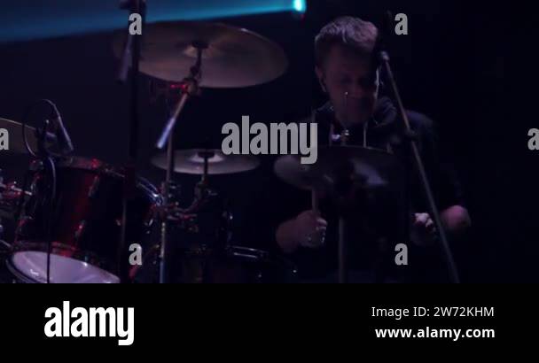 Musician drummer playing against backdrop of bright lights. Live ...