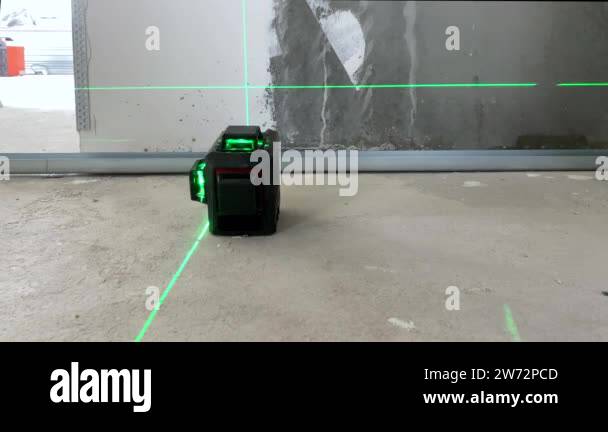 Building worker setting modern laser level on the floor on construction ...