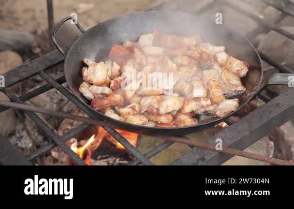 Frying pan with bacon on the fire. A large cast iron skillet with ...