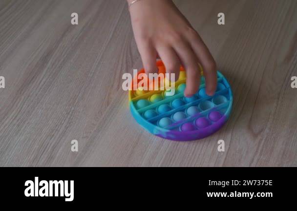 Close up shot of kids fingers on pop it fidget toy. Instrument for ...