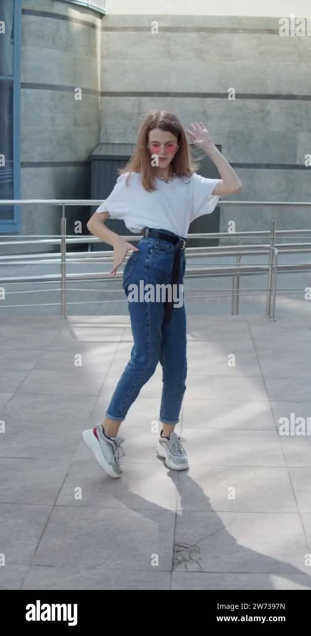 Female young hip-hopper dancing staging on urban street in front of ...