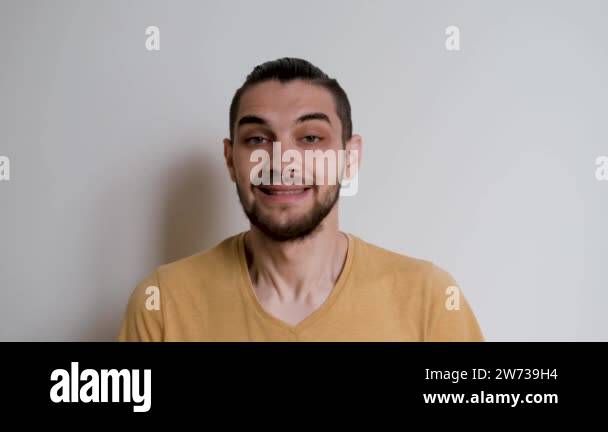 Young good looking white man with beard and ponytail is smiling falsely ...