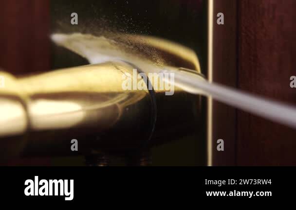 Spraying technical liquid oil and lubricating the golden handle of the ...