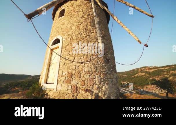 Old traditional historic windmill by the sea at the sunset.Wind power ...