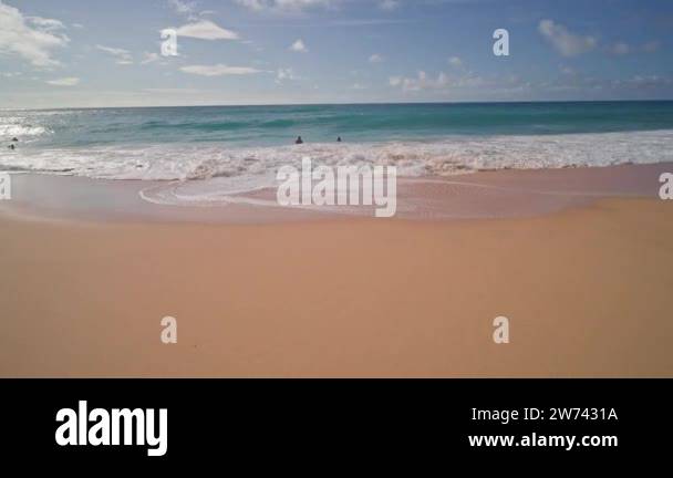 People swim in the ocean. Yellow sand at Sandy Beach on the tropical ...