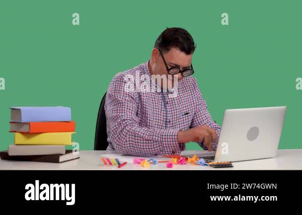 A man sits at a table, uses a laptop, turns off a computer, rejoices ...