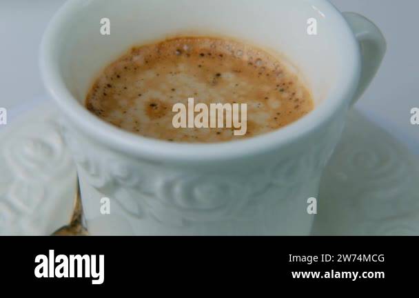 close-up on a white cup of coffee cappuccino, slow motion rotation on a ...