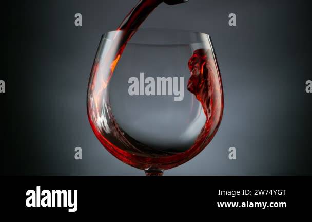 Super slow motion of pouring red wine into glass in detail, speed ramp ...
