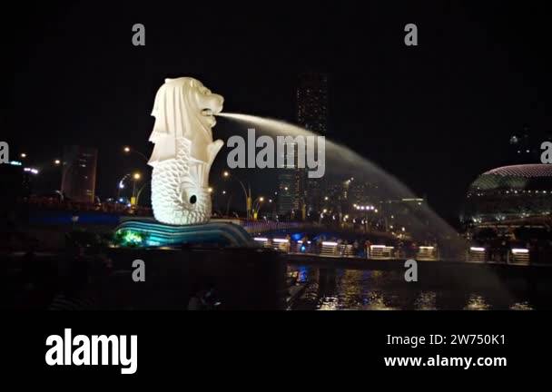 The dramatically lighted Merlion fountain. with a continuous spray of ...
