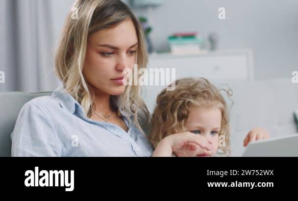 Middle plan of concentrated mum and daughter having fun using learning ...