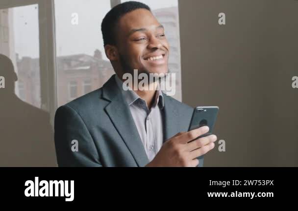 Excited black man working in digital app hold smartphone read good ...