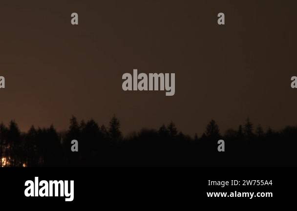 Dark Night Sky With Clouds Moving Fast Behind Large Fir Tree As Full