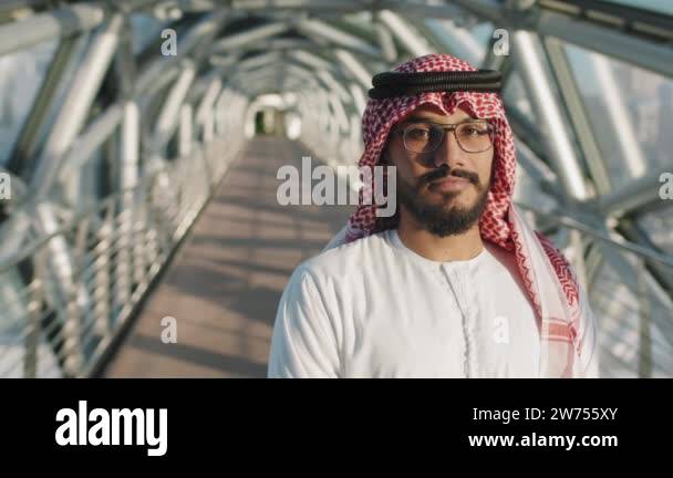 Slowmo waist-up portrait of young wealthy sheikh in traditional ...