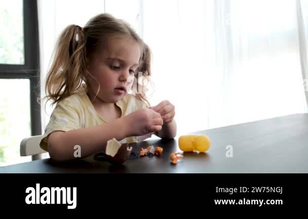 Little girl looks at instruction to assembly toy at table Stock Video ...