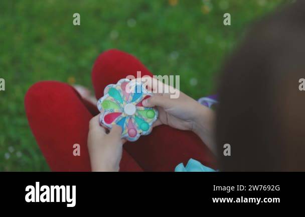 The child is playing a popular game with buttons, an anti-stress toy ...