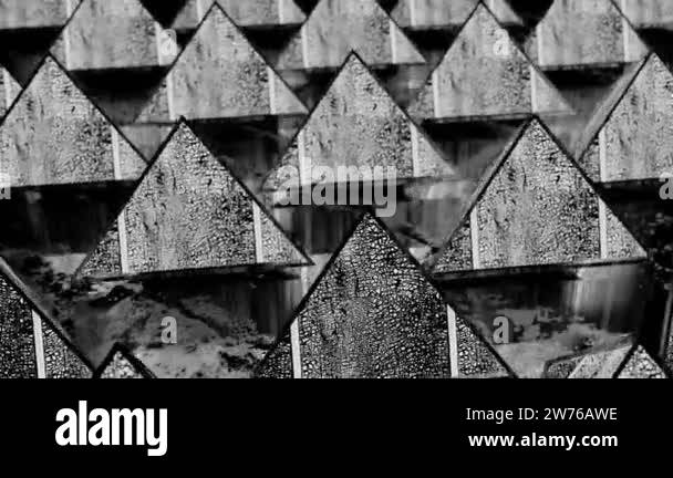 rotating rows of black and white pyramids with cracked texture. looped ...
