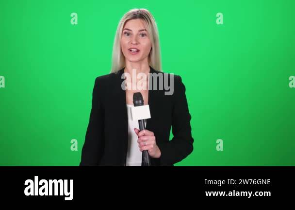 Female reporter in suit looks into the camera and speaks into a ...