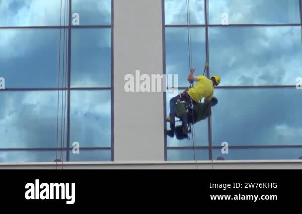 Glass window cleaner washer works outside the building. Professional ...