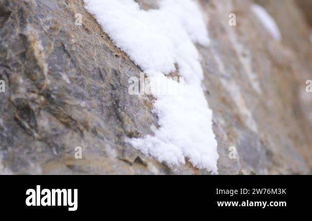 Snow layers accumulating on rock in hard stormy cold weather in winter ...