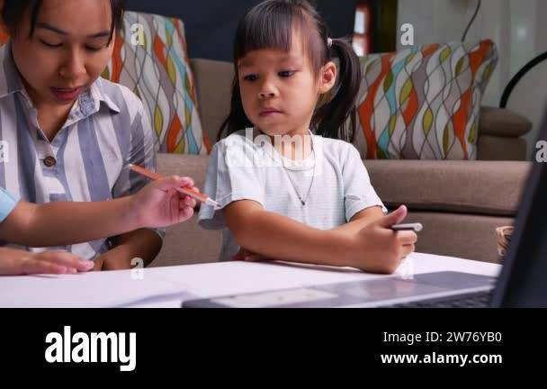 Mother and daughters learned to draw through the laptop computer in the living room. Mother ...