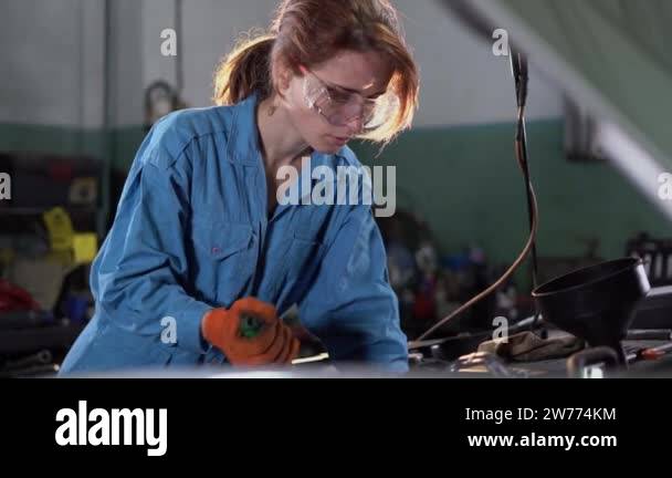 Portrait of a woman mechanic working in a car service. Empowering a ...