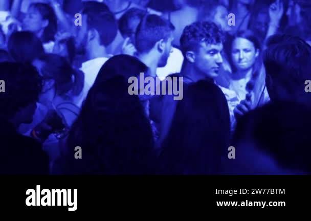 People Dancing in Night Club, flashing light and young men and woman ...