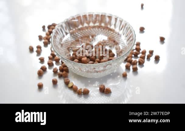 Falling Black grams raw pulse seeds in crystal clear bowl isolated on ...