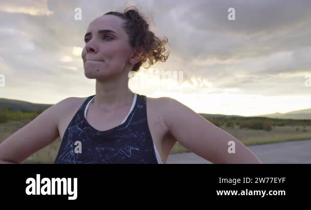 Fit and active young woman taking a break from jog. Tired runner ...