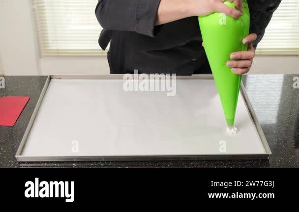 Pastry chef makes Anna Pavlova mini cakes, pour the filling using a ...