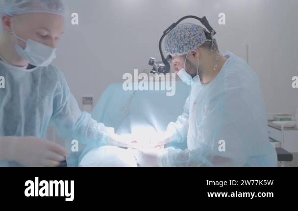 Two surgeons perform operation on man. Action. Surgeons professionally ...