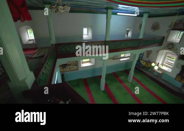 Muslim mosque teacher is reading quran in small historic wooden masjid ...