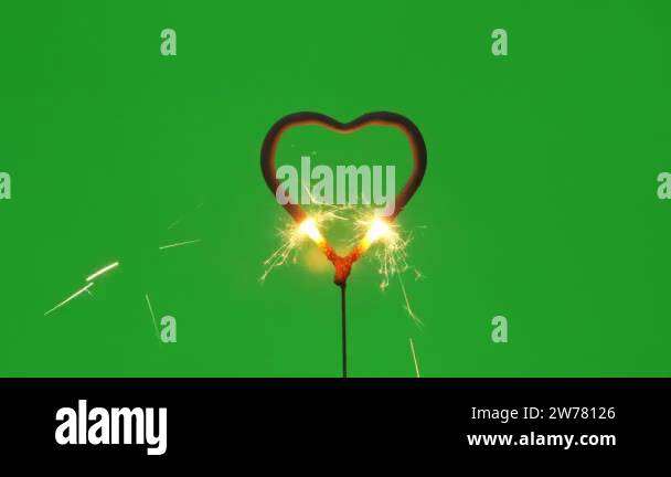 Burning bengal fire in heart shape and sparks on green background in 4K ...