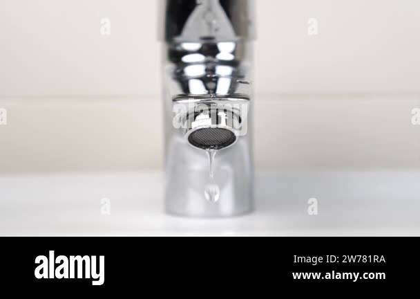 Dripping stainless faucet with water drops close-up. Fluid leaking from ...
