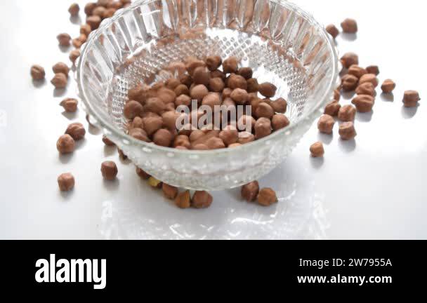 Falling Black grams raw pulse seeds in crystal clear bowl isolated on ...