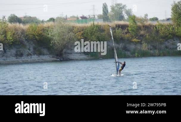Man on The Windsurf Board With Sail is Floating Fast by Watery Surface ...